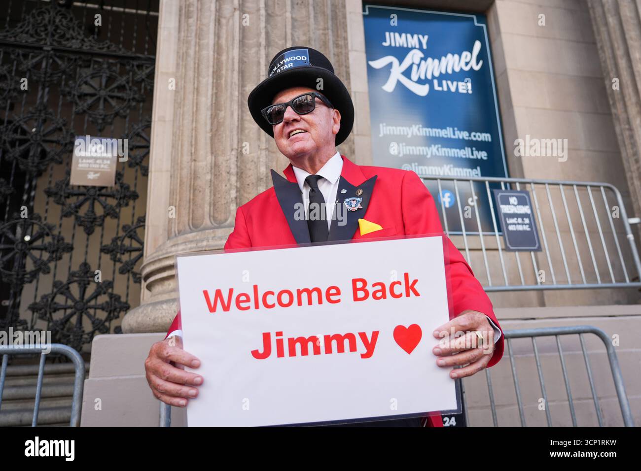 Gregg Donovan holds a sign that says "Welcome Back Jimmy" in front of ...