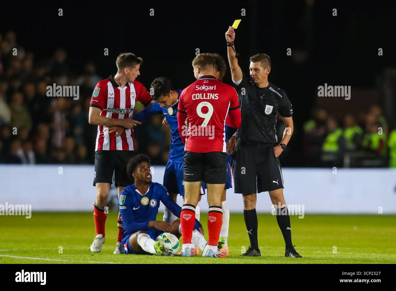 James Collins Of Lincoln City is is shown a yellow card by Referee ...