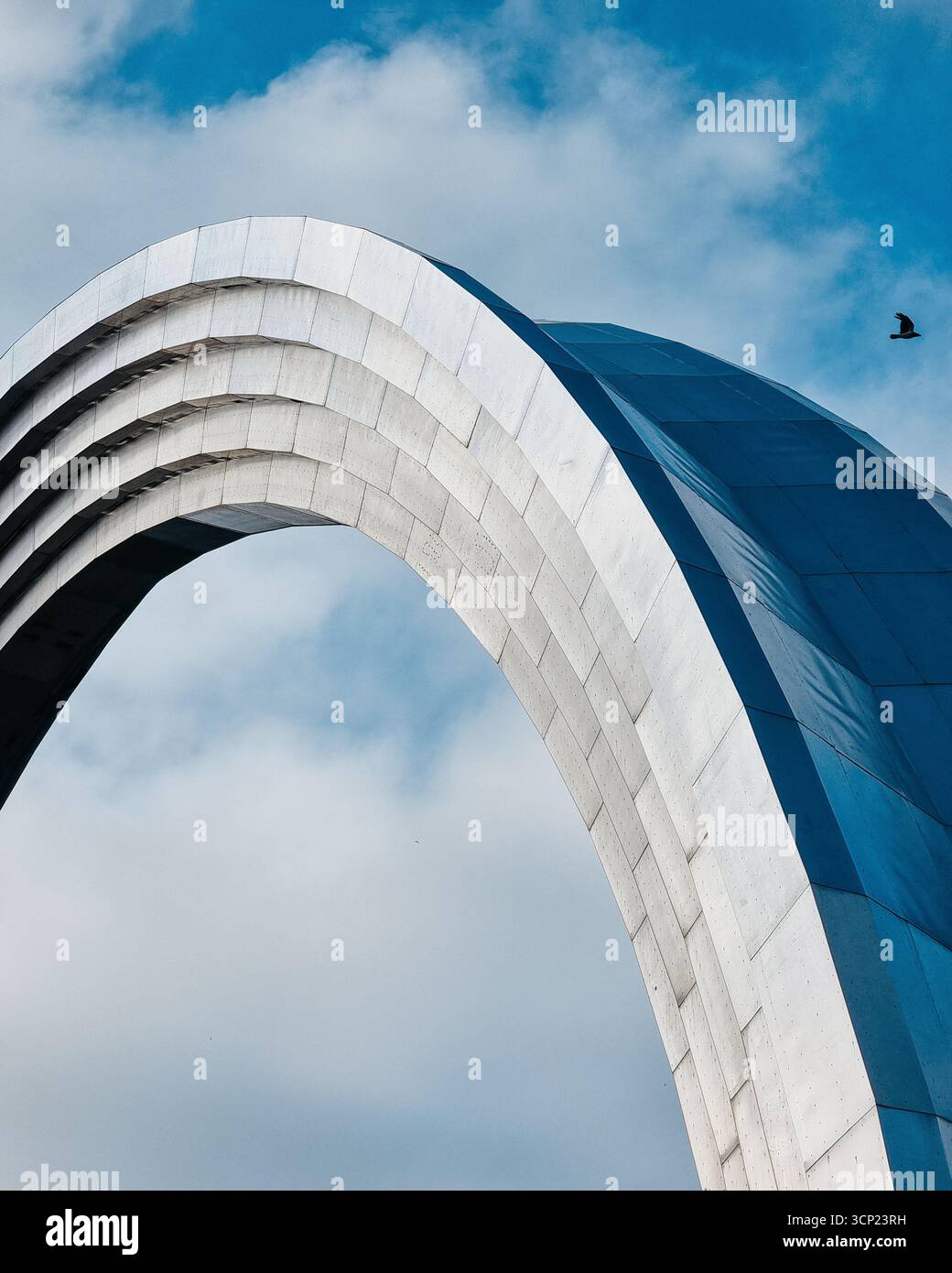 Big metal arch in cloudy sky. High-tech titanium curve made of lots of ...