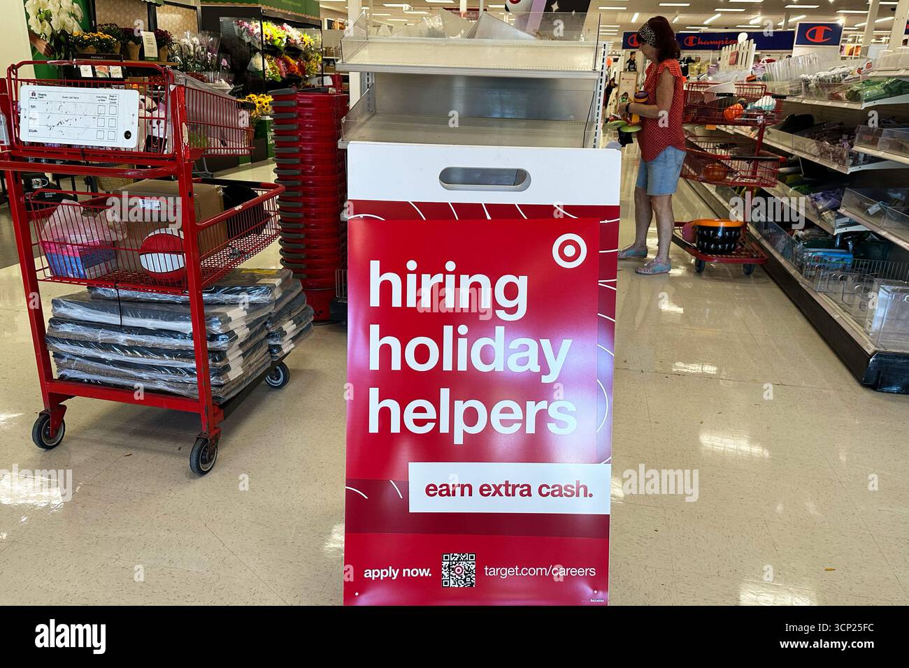 A hiring holiday helpers sign is displayed at a retail store in ...