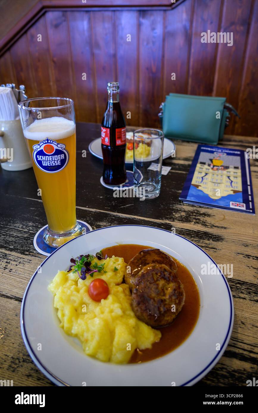 Traditional Bavarian meal with mashed potatoes, meat patties, and beer ...
