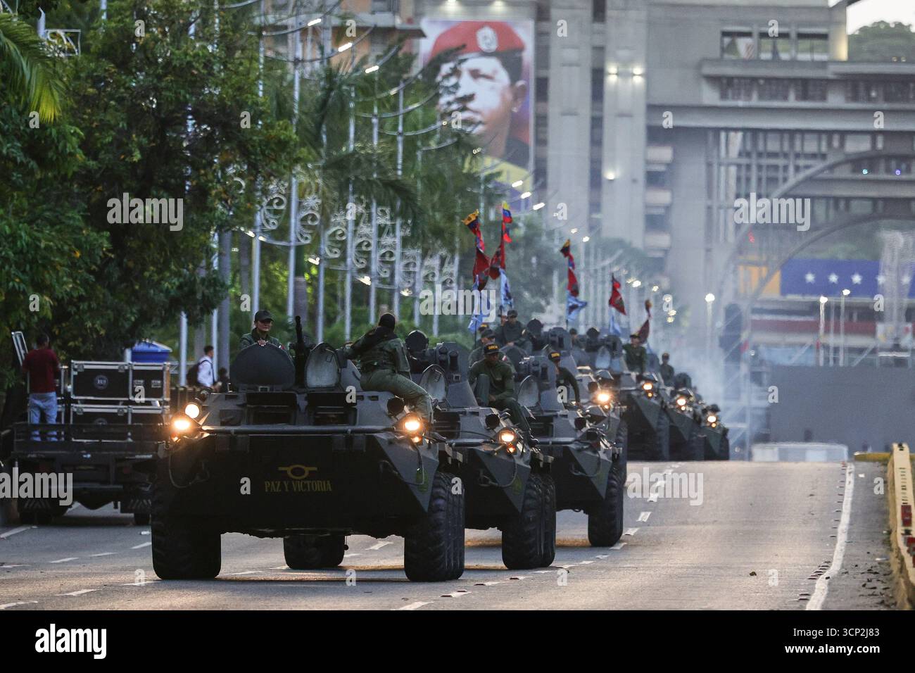 Armored vehicles drive through a street during a government-organized ...