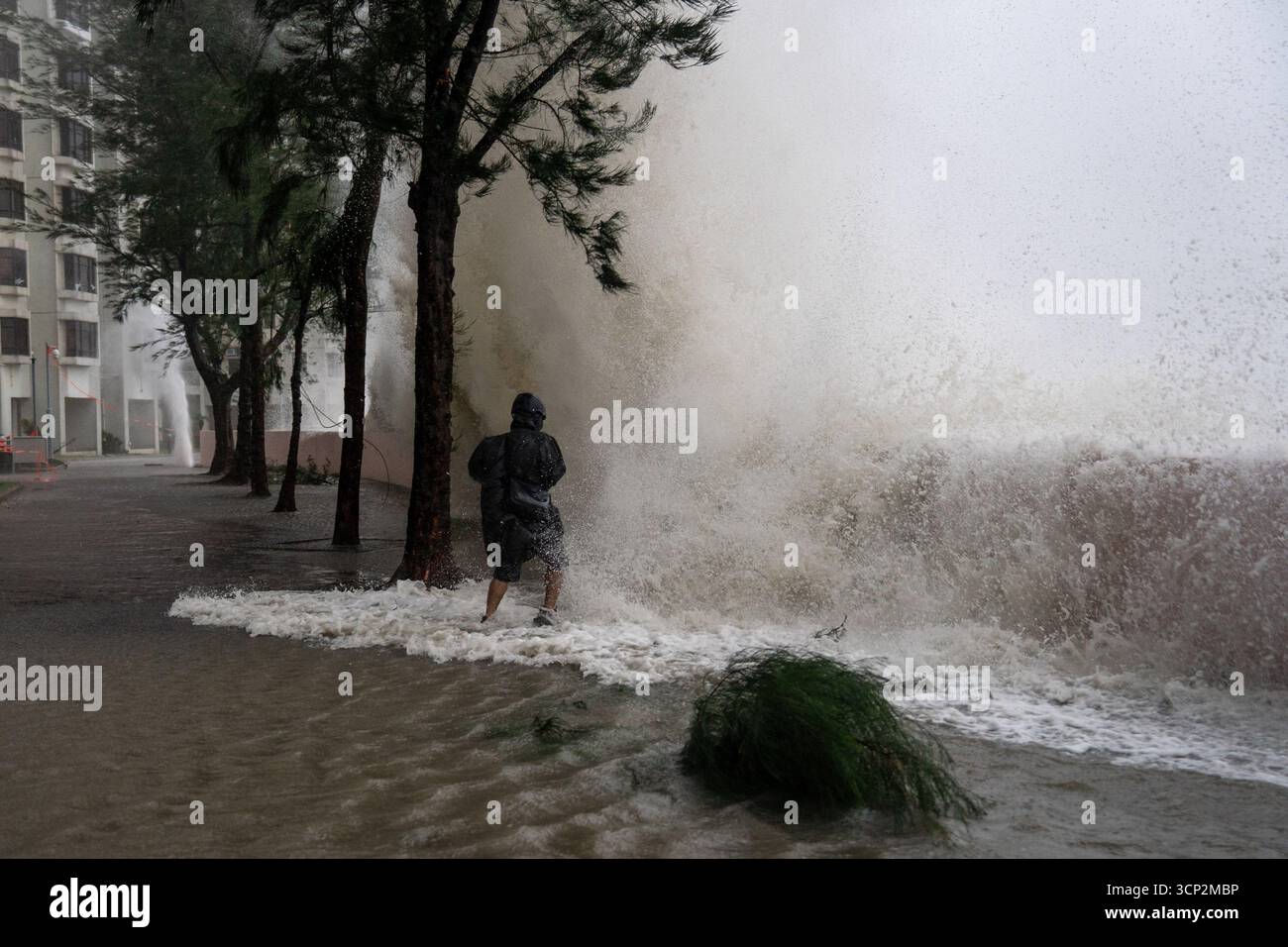 A man being splash by waves at Heng Fa Chuen as Typhoon Ragasa passes ...