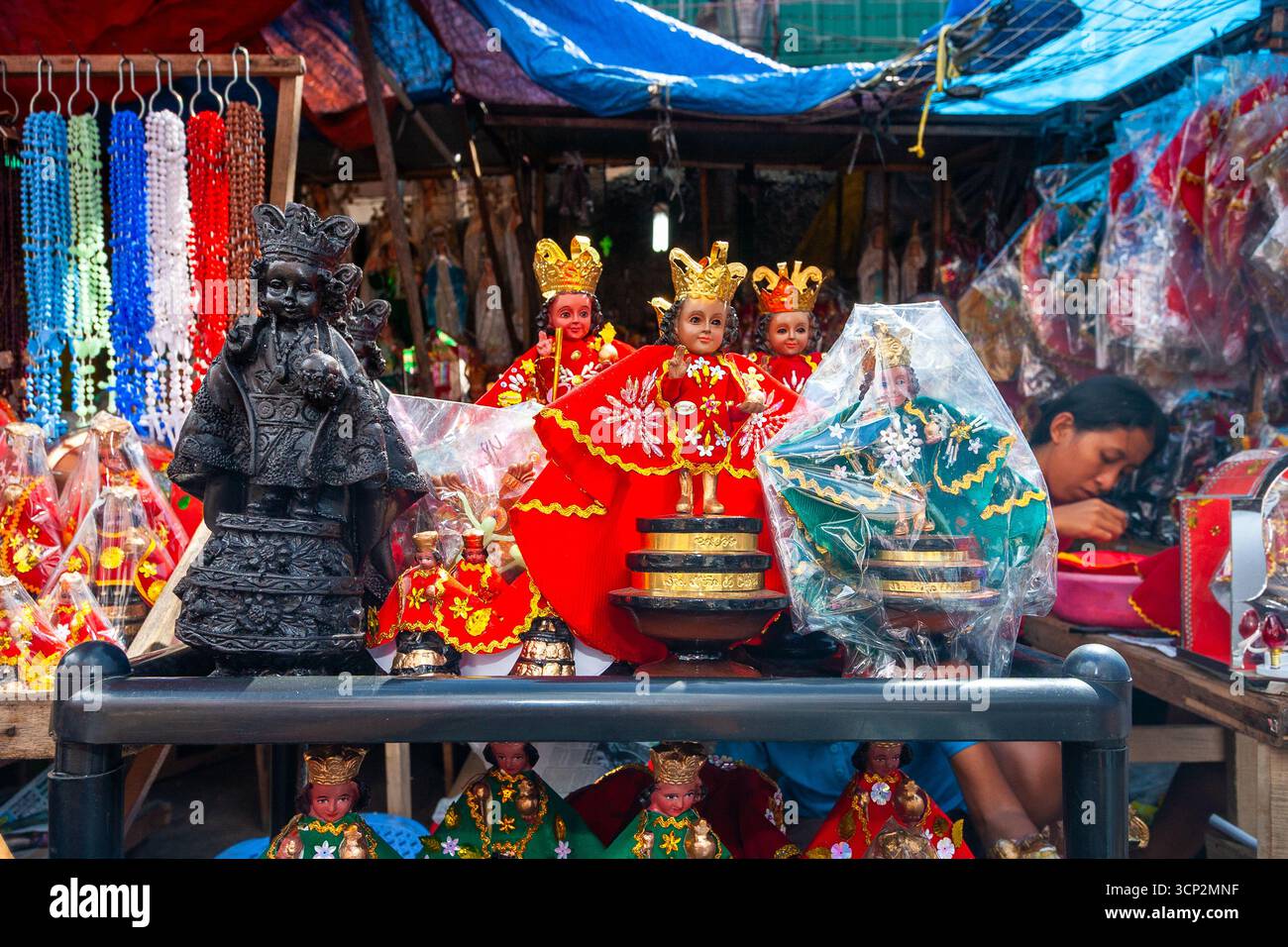 An artisan dressing an image of the Sto Niño de Cebu for sale around ...