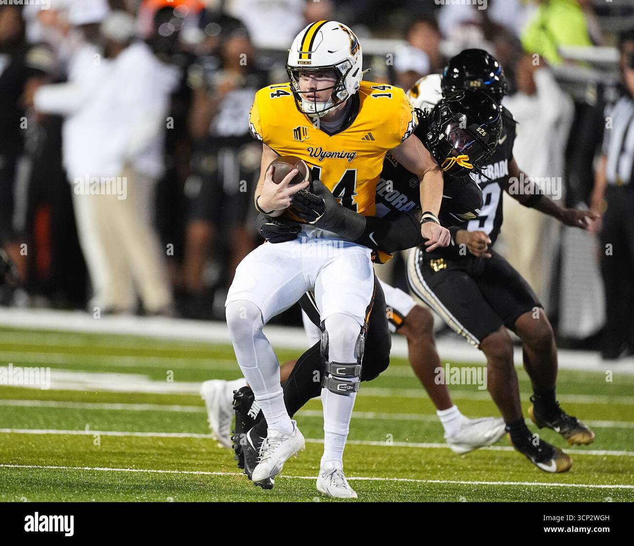 Wyoming quarterback Landon Sims (14) is stopped after a short gain by ...