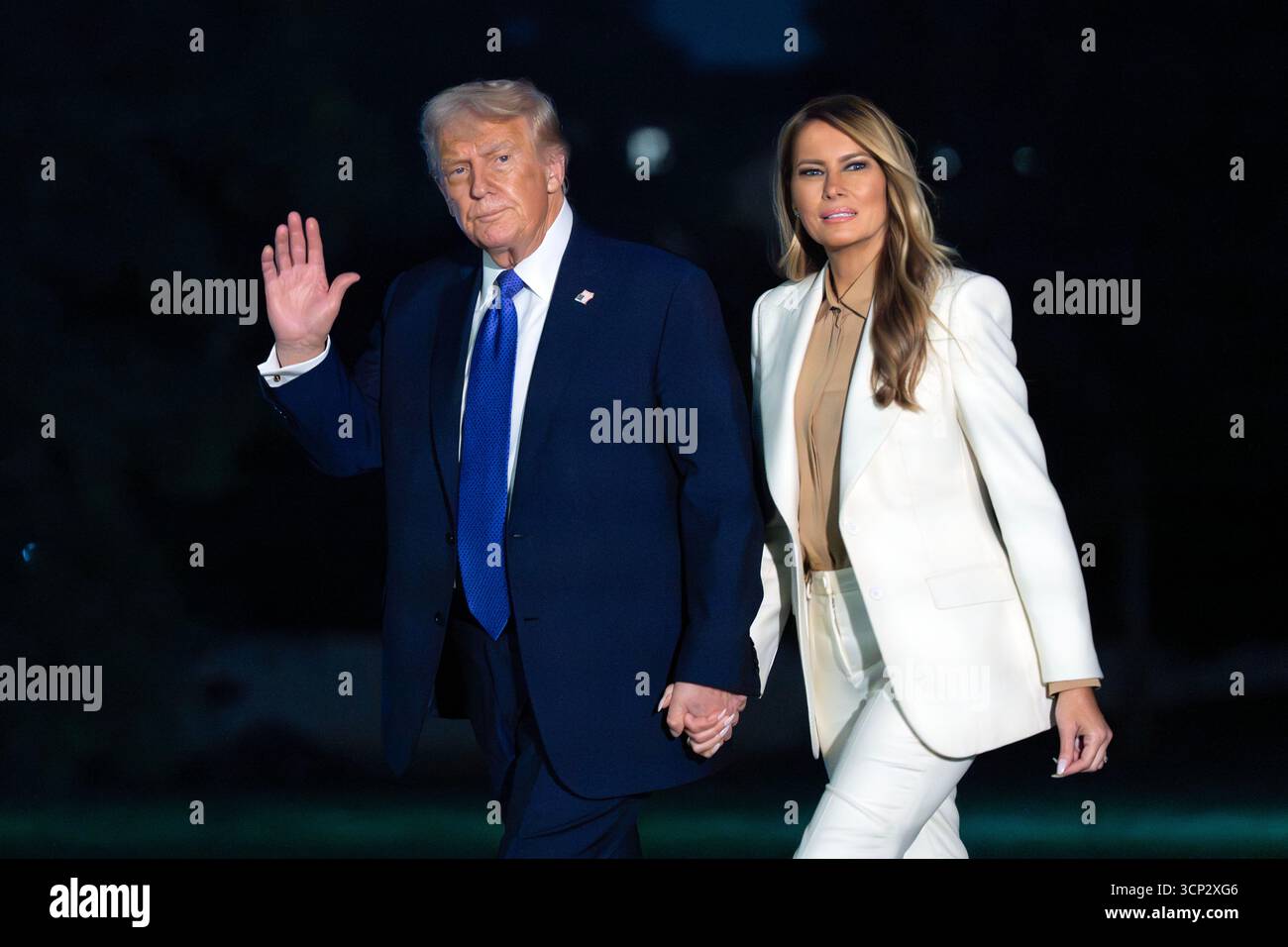 President Donald Trump waves to media while holding hands with first ...