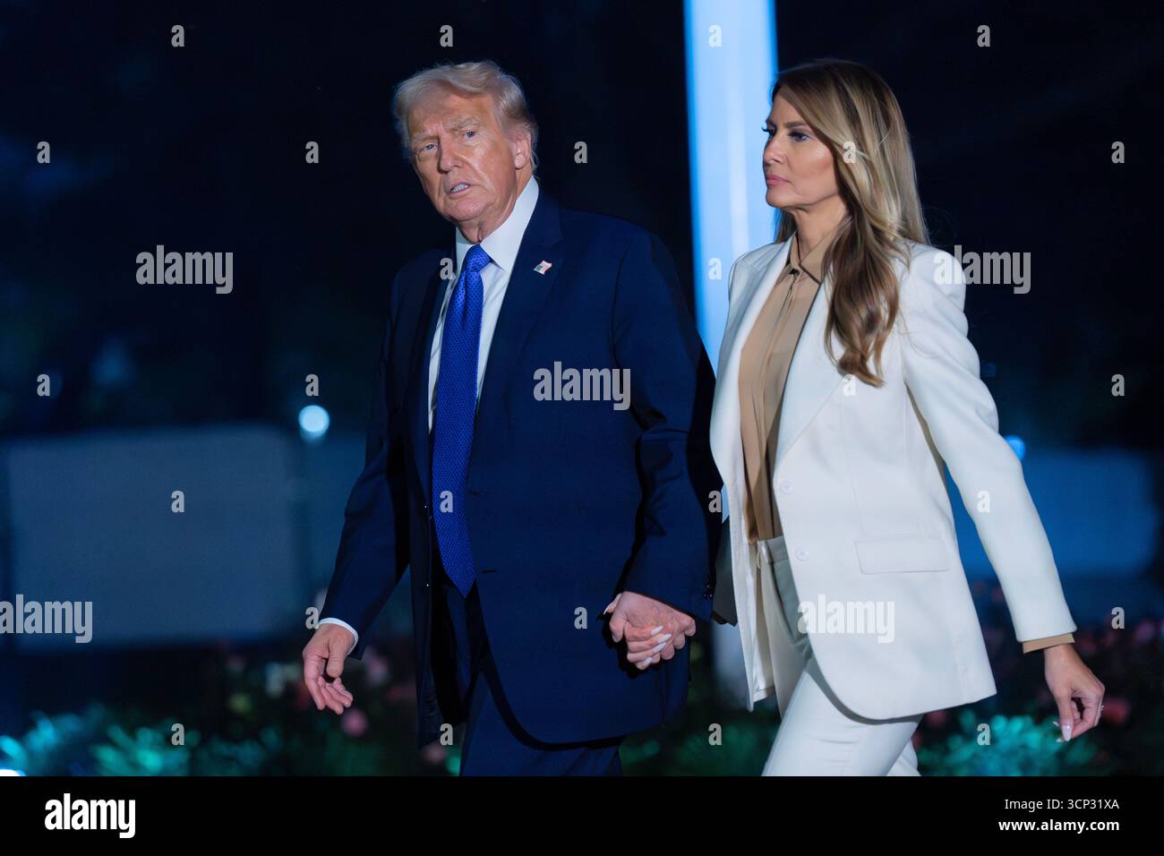 President Donald Trump hold hands with first lady Melania Trump as they ...