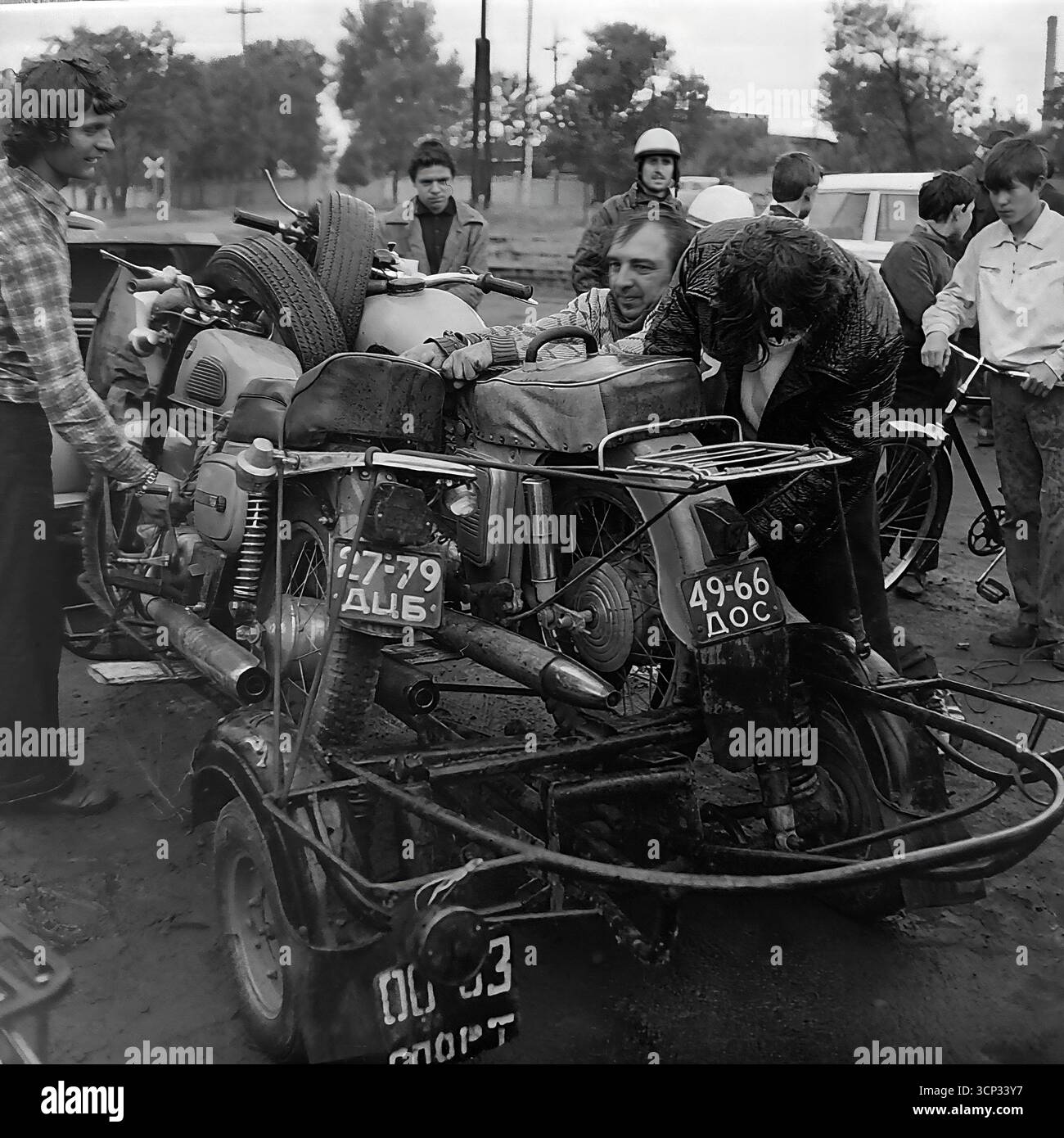 A team of Soviet motorcycle racers and their support crew gather around ...