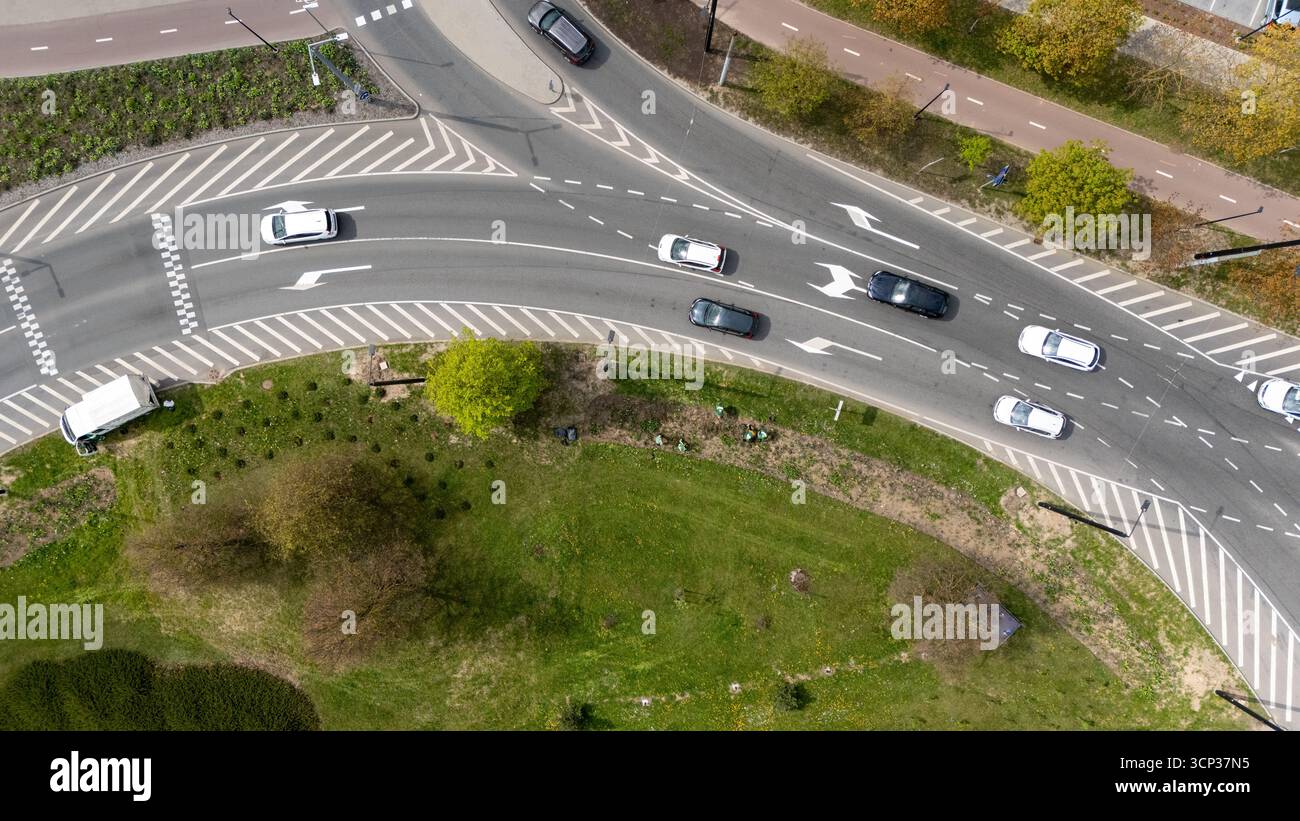 Aerial view of a curved road with multiple lanes and cars, surrounded ...