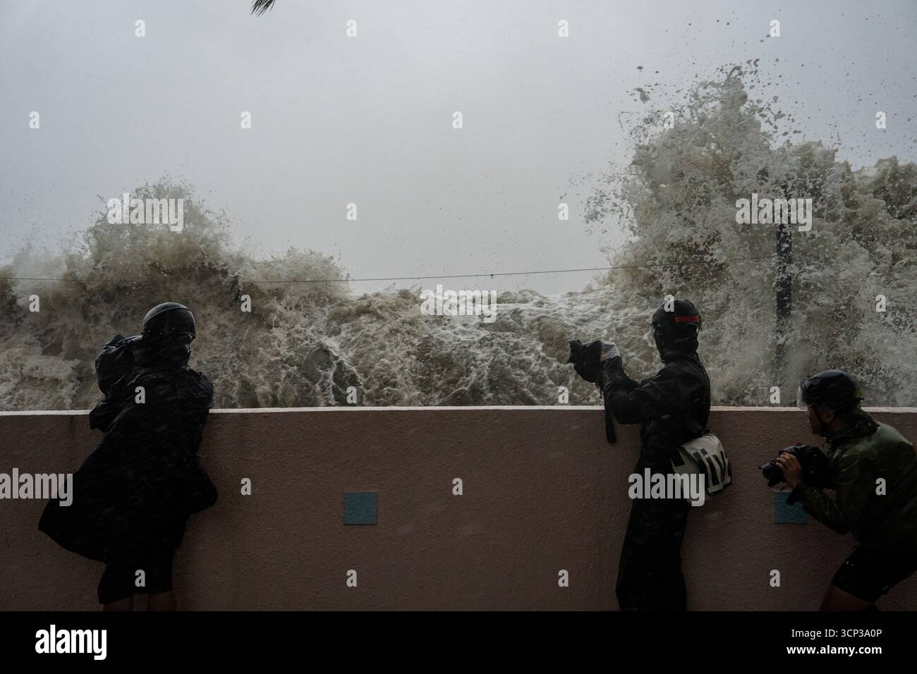 Photographer being splashed by waves splashing onto the shore at Heng ...