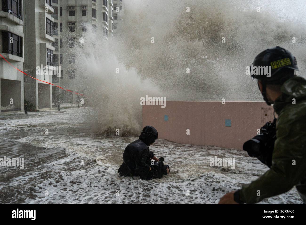 A man falls to the ground after being splash by waves at Heng Fa Chuen ...