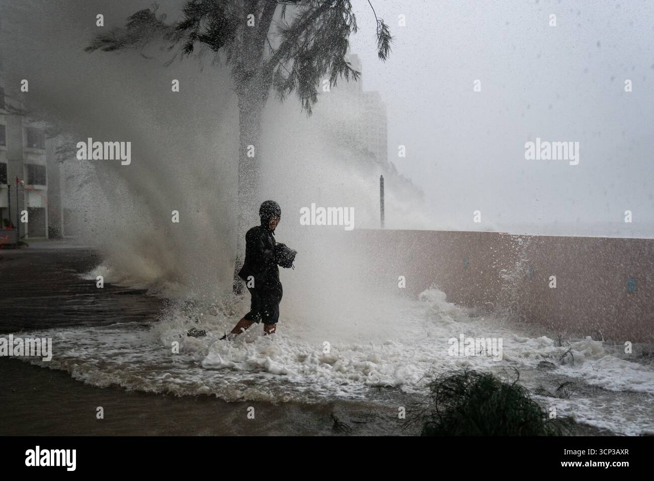 A man being splash by waves at Heng Fa Chuen as Typhoon Ragasa passes ...