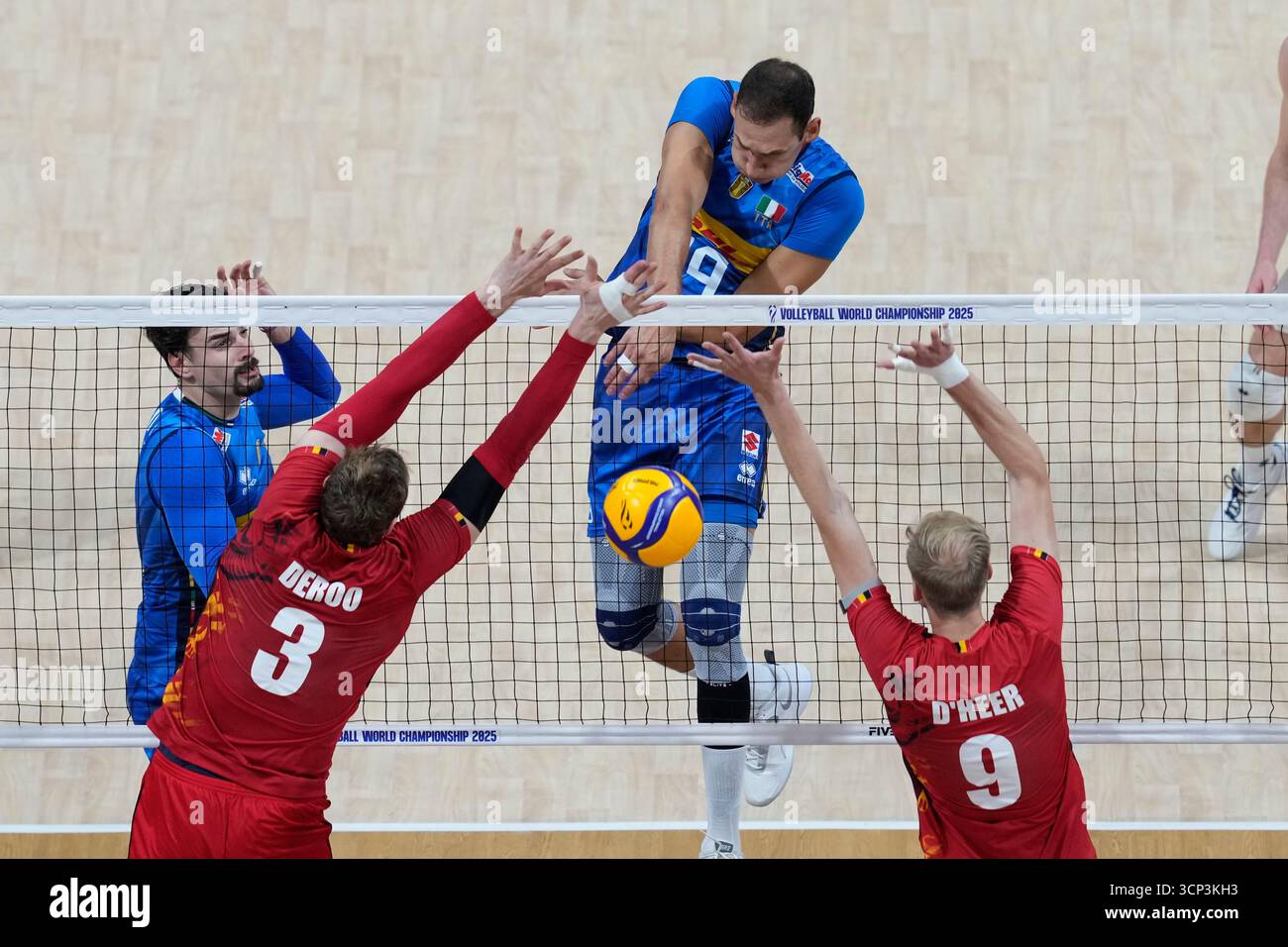 Roberto Russo of Italy spikes the ball against Sam Deroo of Belgium and ...