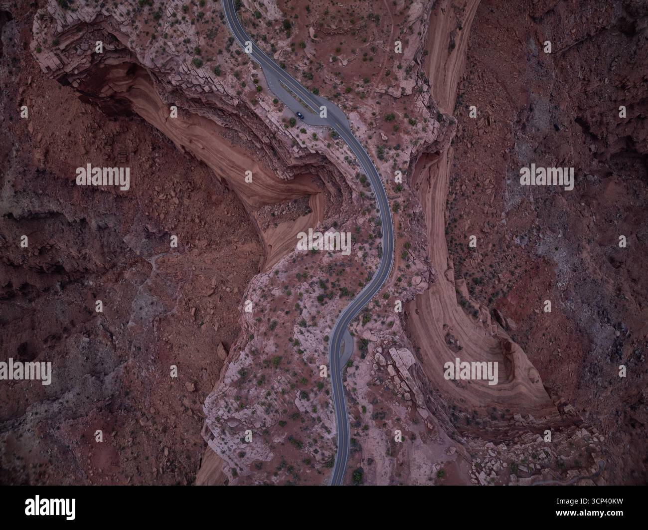 Aerial view of a sinuous road cutting through the rugged, rust-colored ...