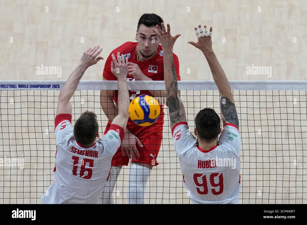 Bedirhan Bulbul, of Turkey spikes the ball through Polish players from ...