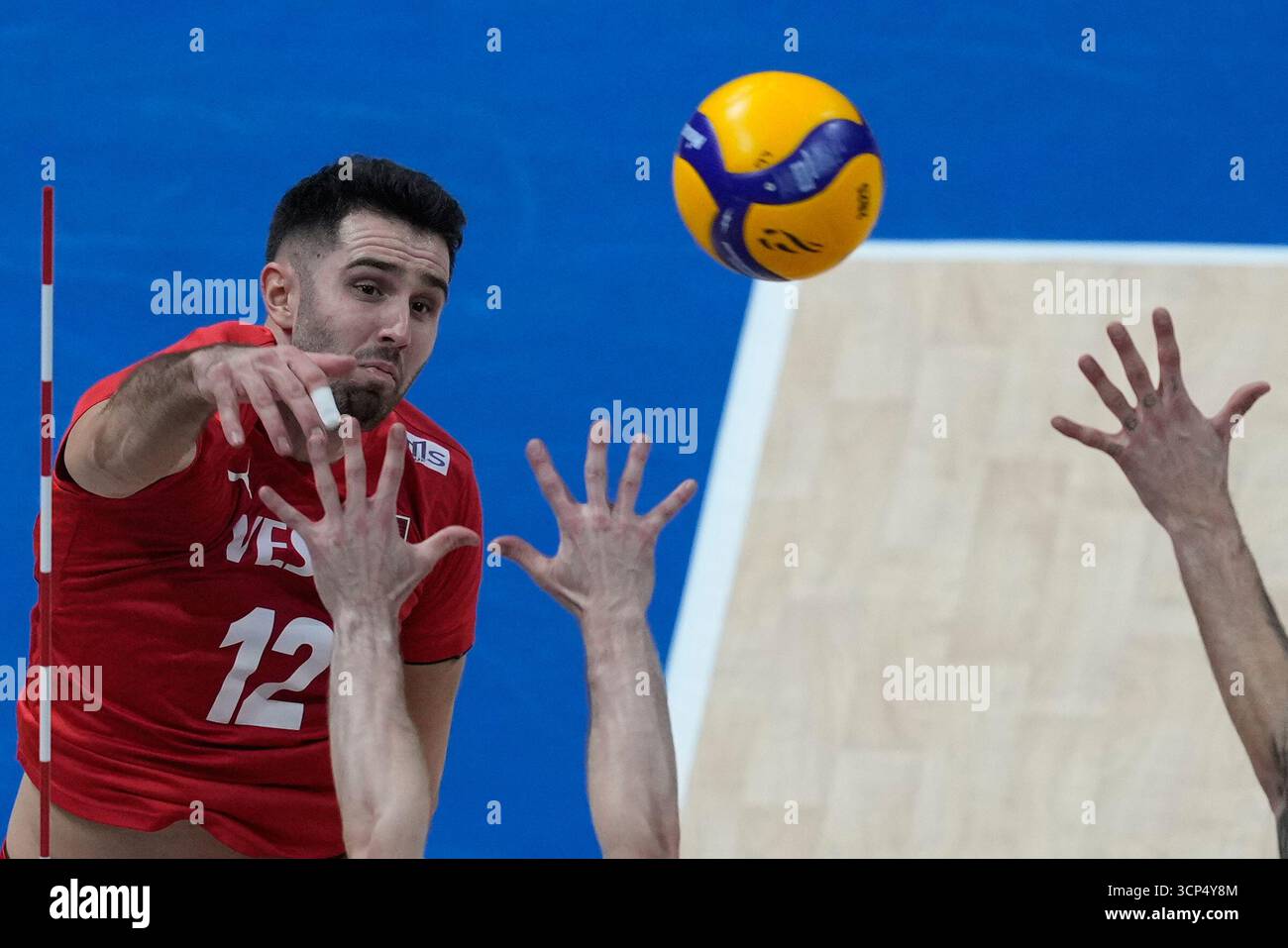 Adis Lagumdzija, of Turkey spikes the ball through Polish players ...