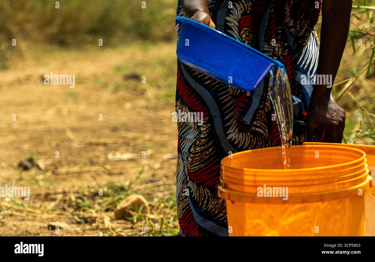 African woman collecting water from ground in rural Mozambique Stock ...