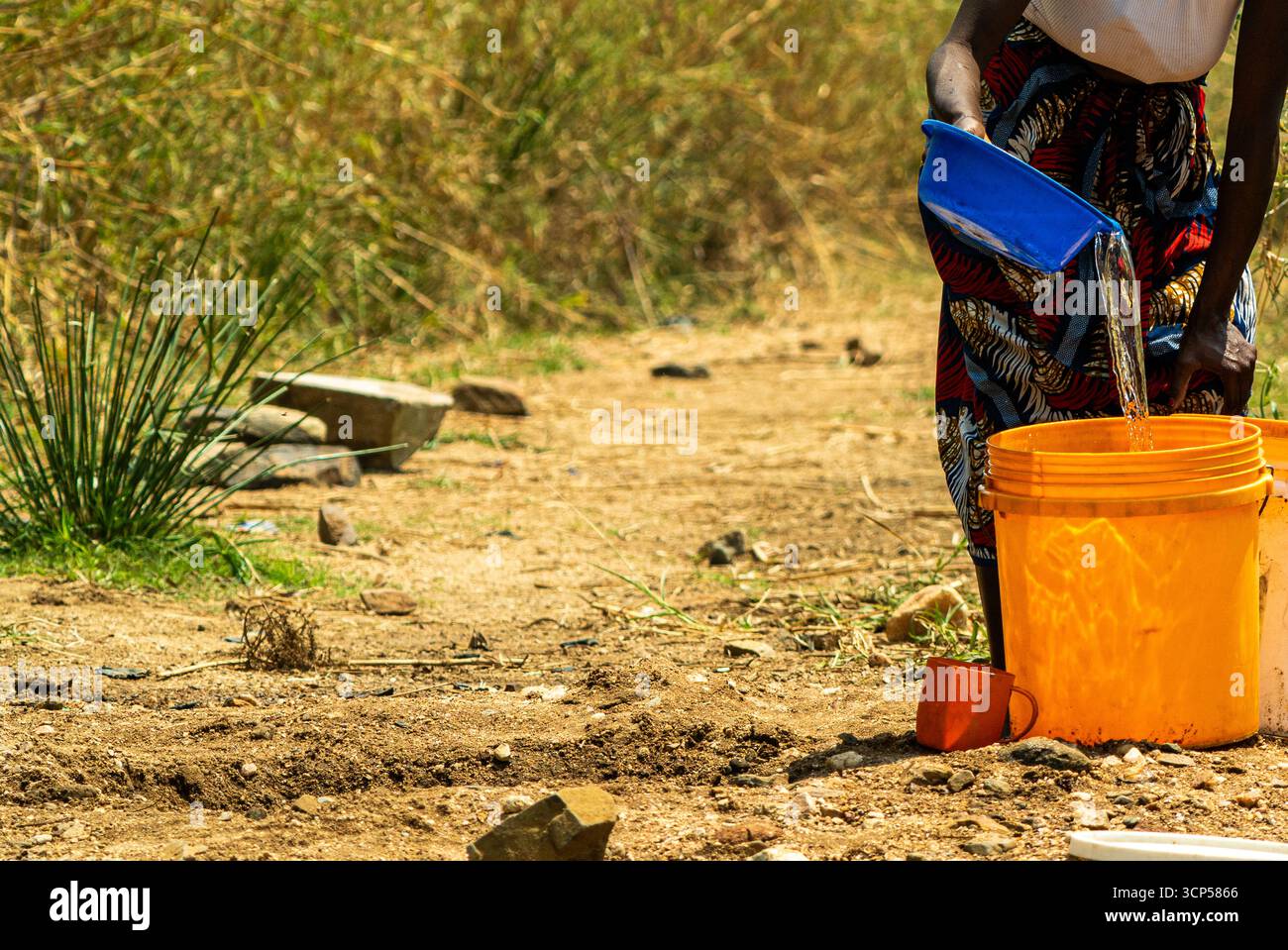 African woman collecting water from ground in rural Mozambique Stock ...