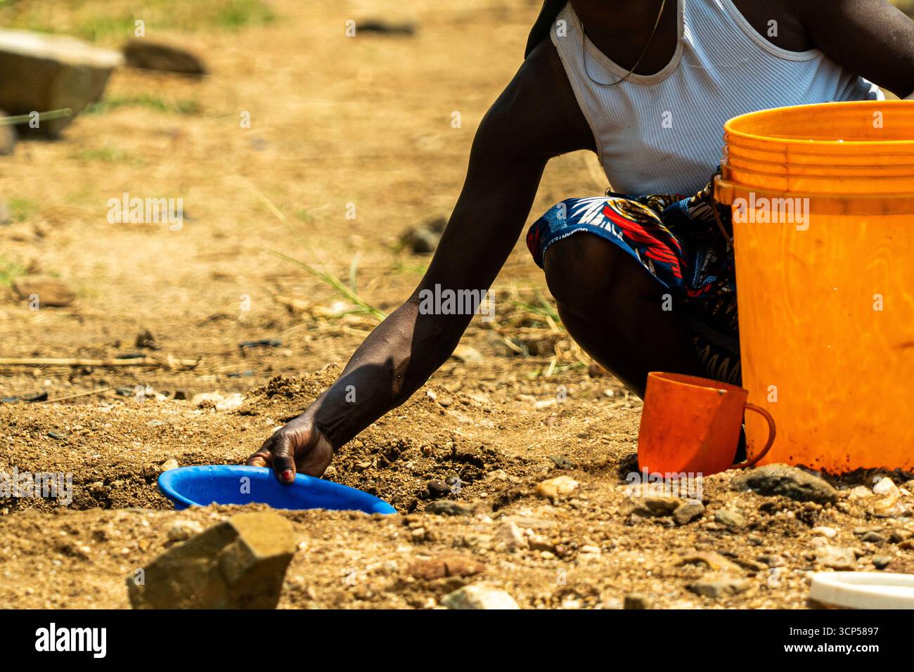 African woman collecting water from ground in rural Mozambique Stock ...