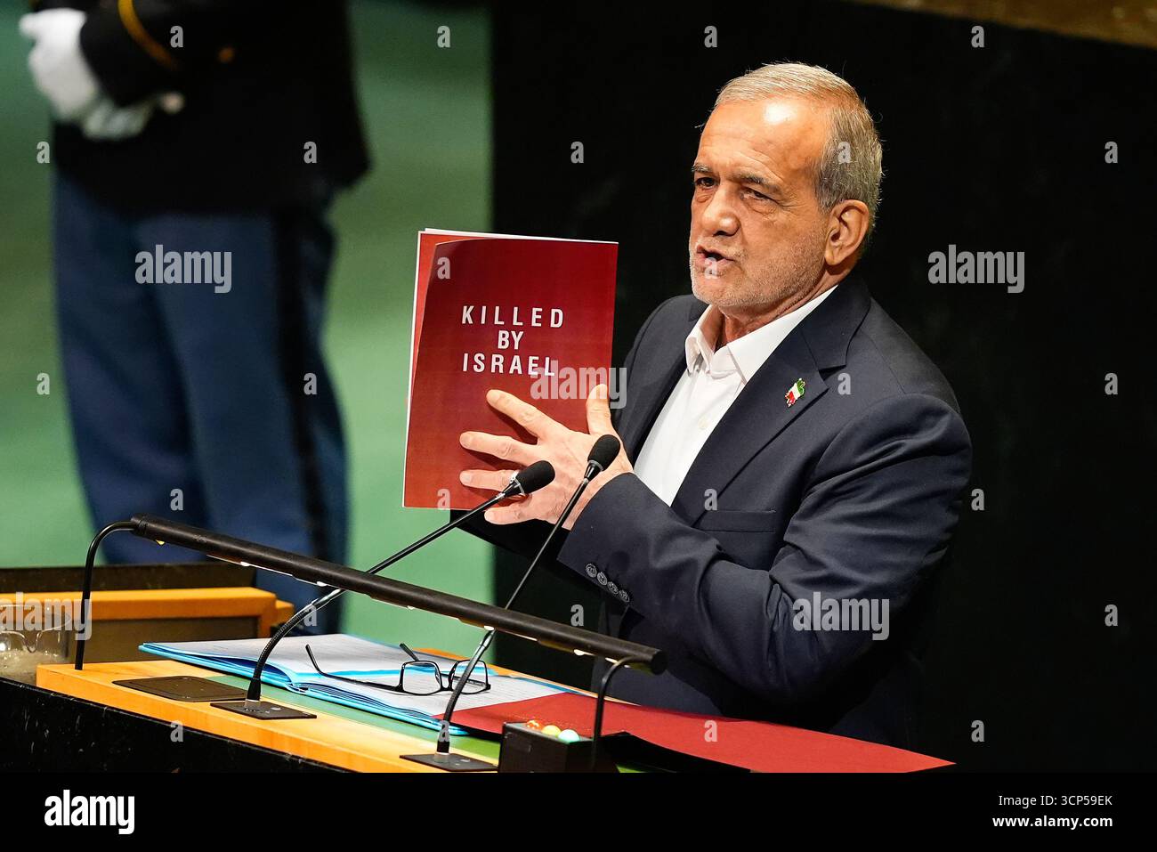 Iran President Masoud Pezeshkian holds up a book while speaking during ...