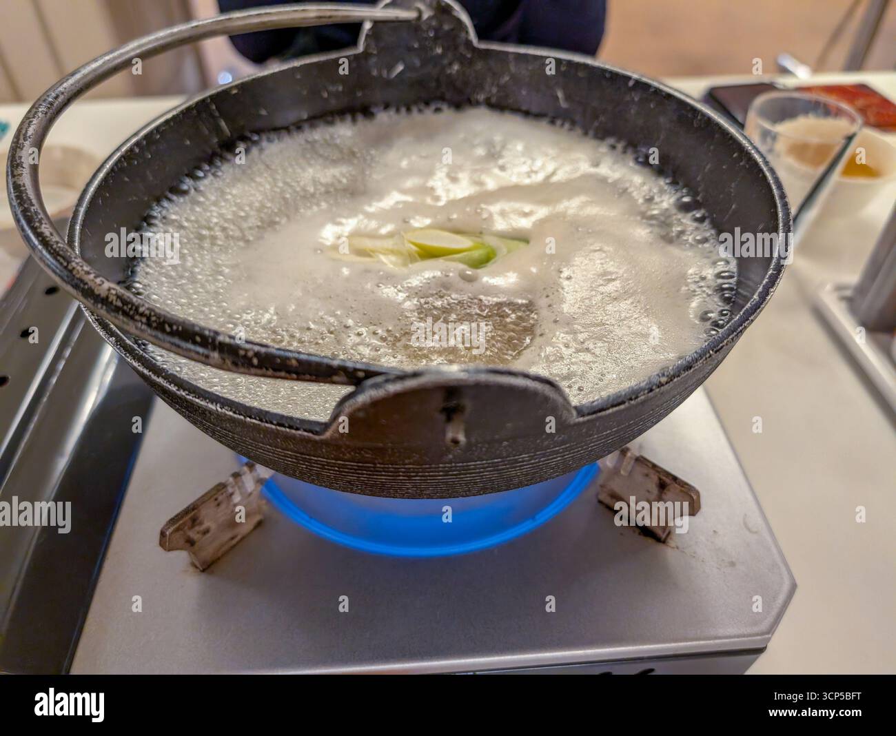 Boiling Japanese nabe hot pot with vegetables simmering on a portable ...