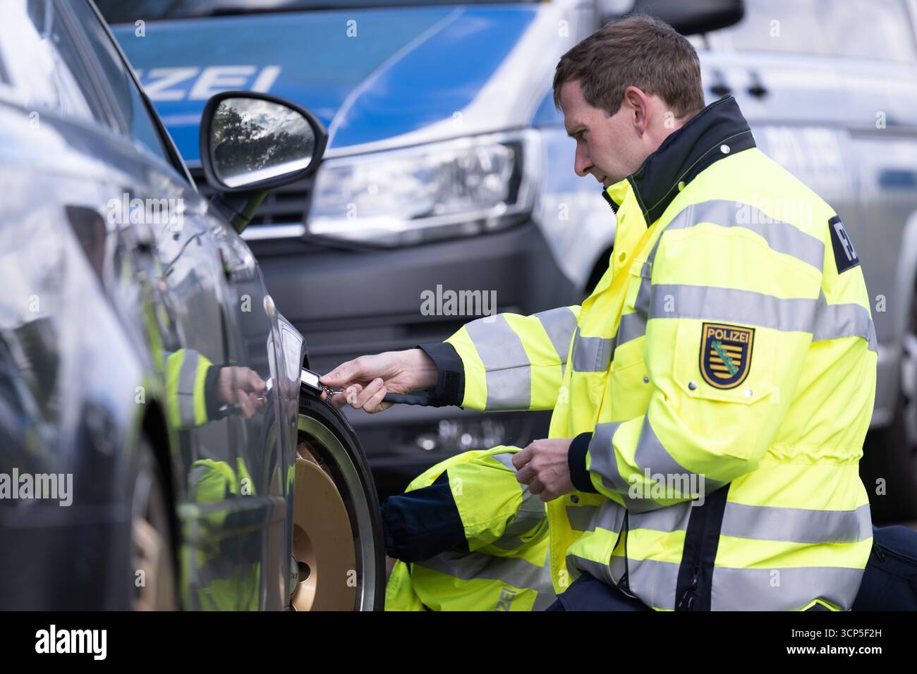 Dresden, Germany. 24th Sep, 2025. Police officers inspect a car during ...