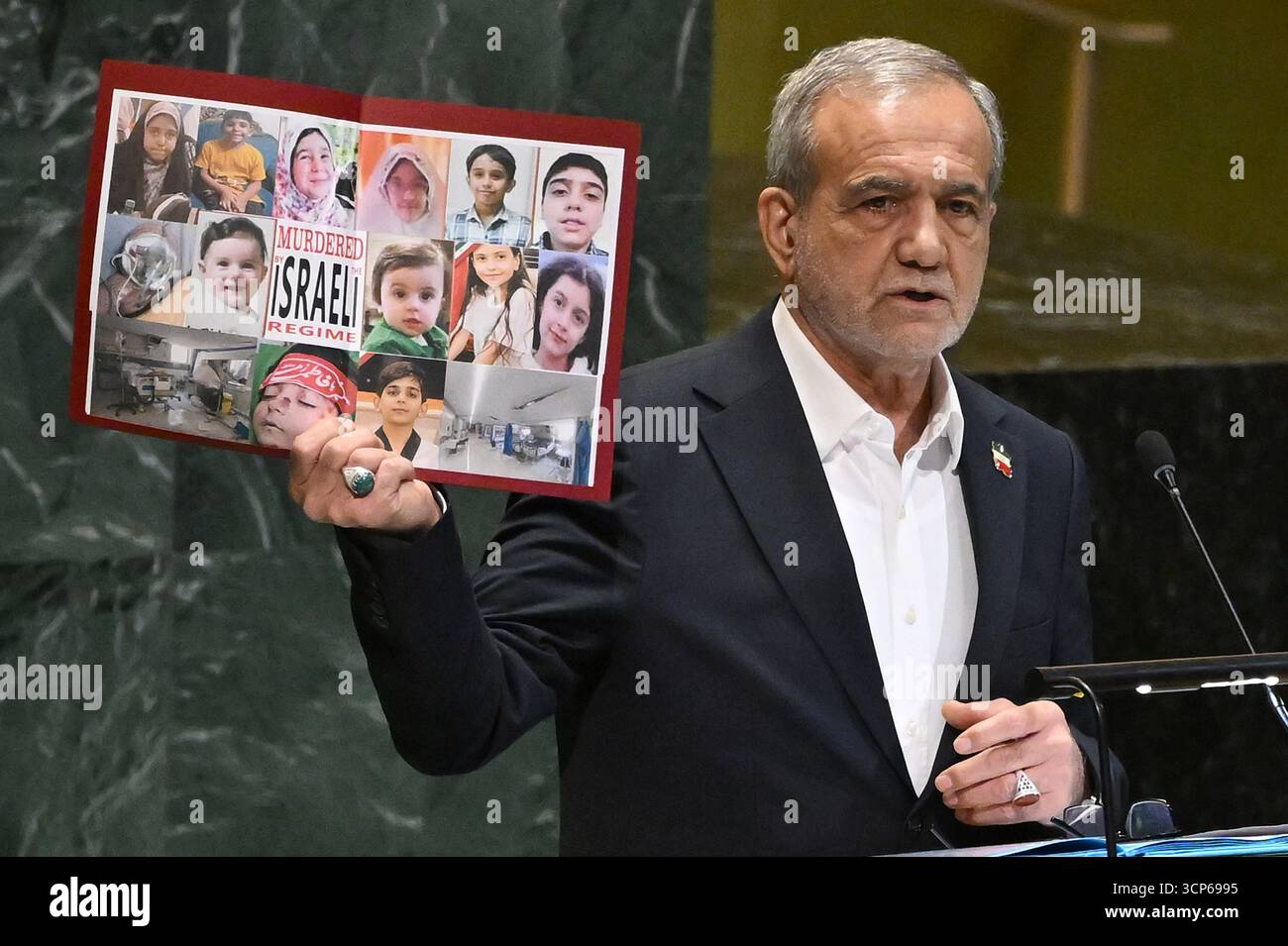 President of Iran Masoud Pezeshkian holds a book with images of ...