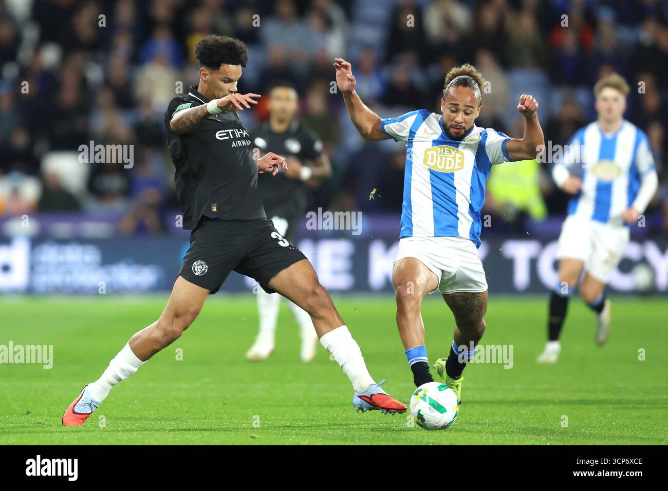 Manchester City's Nico O'Reilly (left) and Huddersfield's Marcus ...