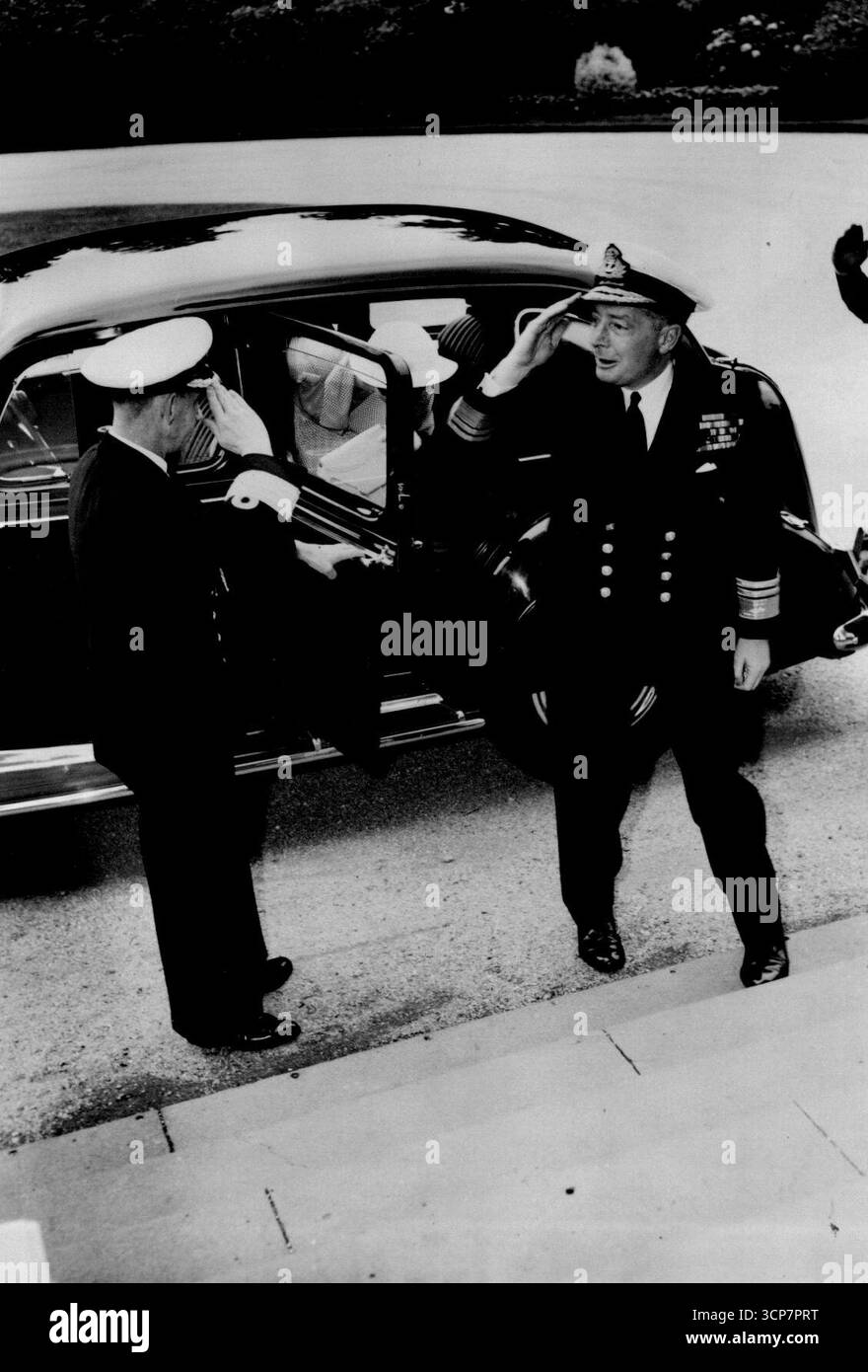 Vice-Admiral Sir John Collins returns a salute as he arrives at ...