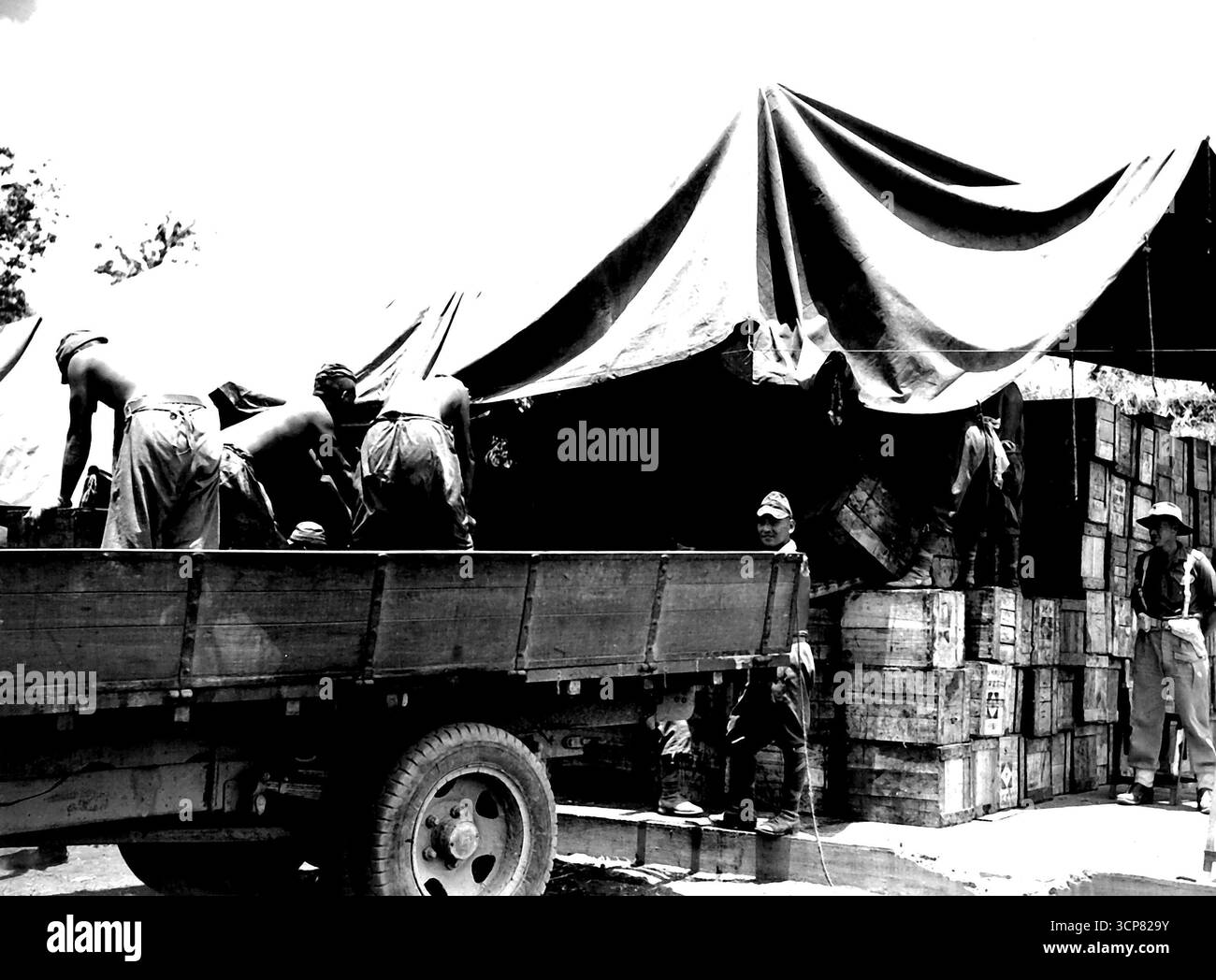 A Japanese working party unloading cases of beer which will be issued ...