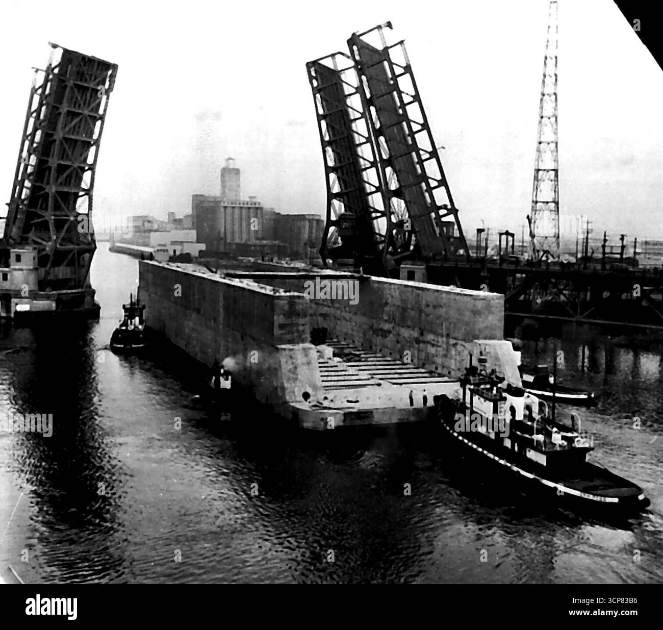 Floating Acre of Concrete -- Tugs slowly inch a huge 400-foot floating ...