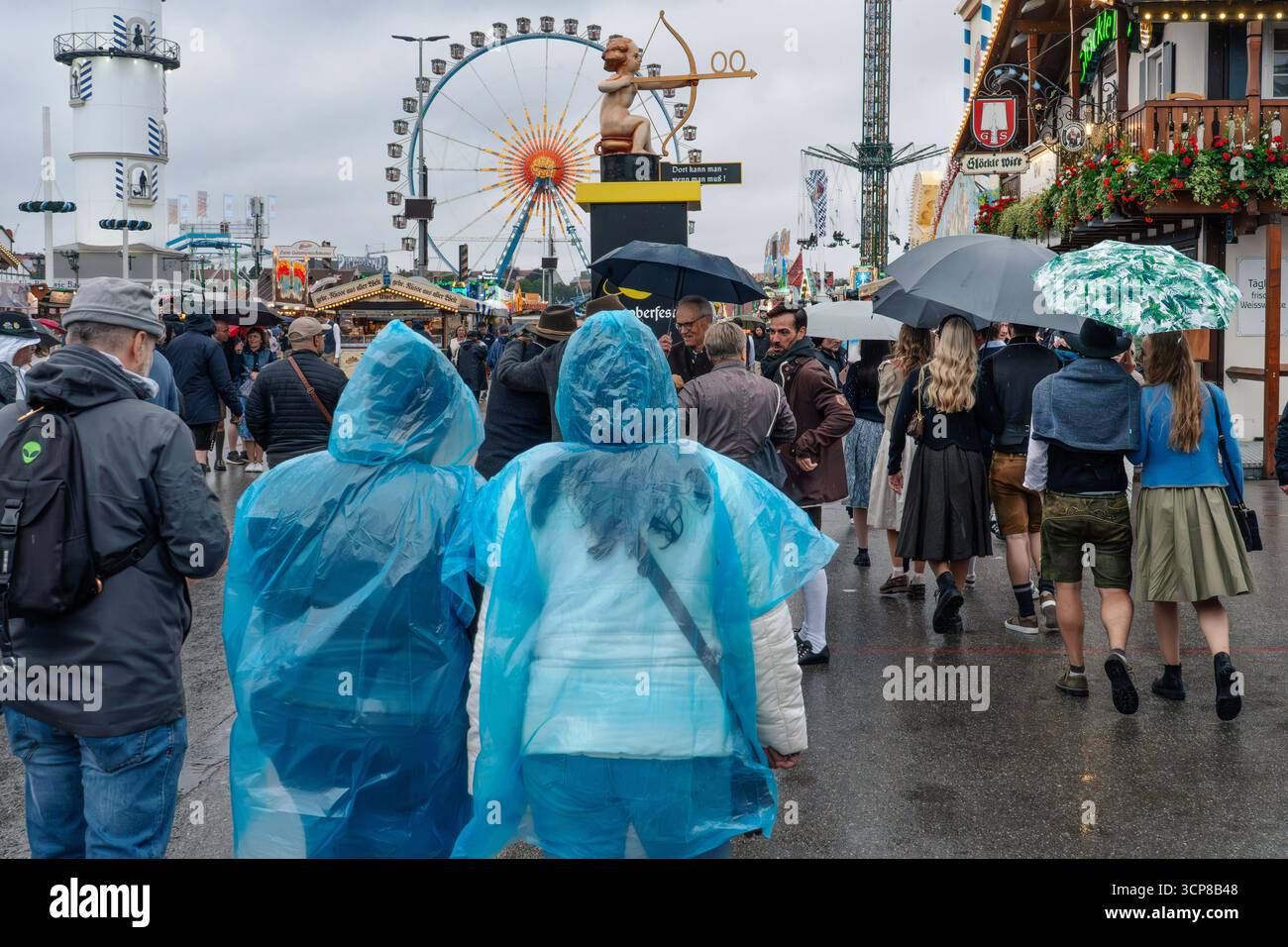 Oktoberfest im Regen, Wiesnbesucherinnen mit Regenponchos schlendern ...
