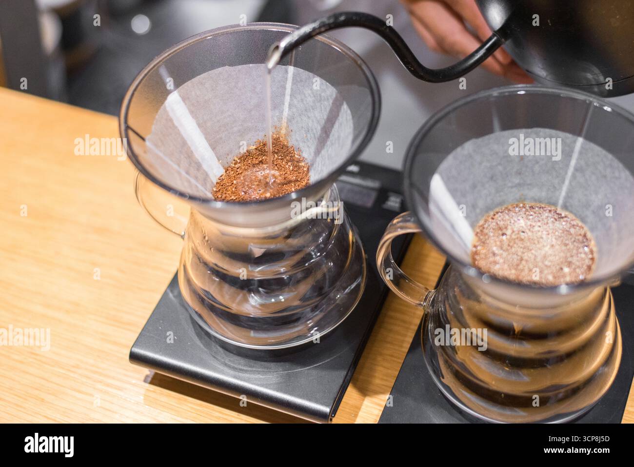 Close up picture of japanese barista adding hot water over ground ...
