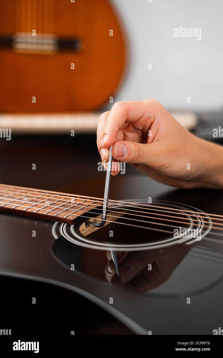 Adjusting a guitar truss rod. Guitarist adjusting the truss rod inside ...