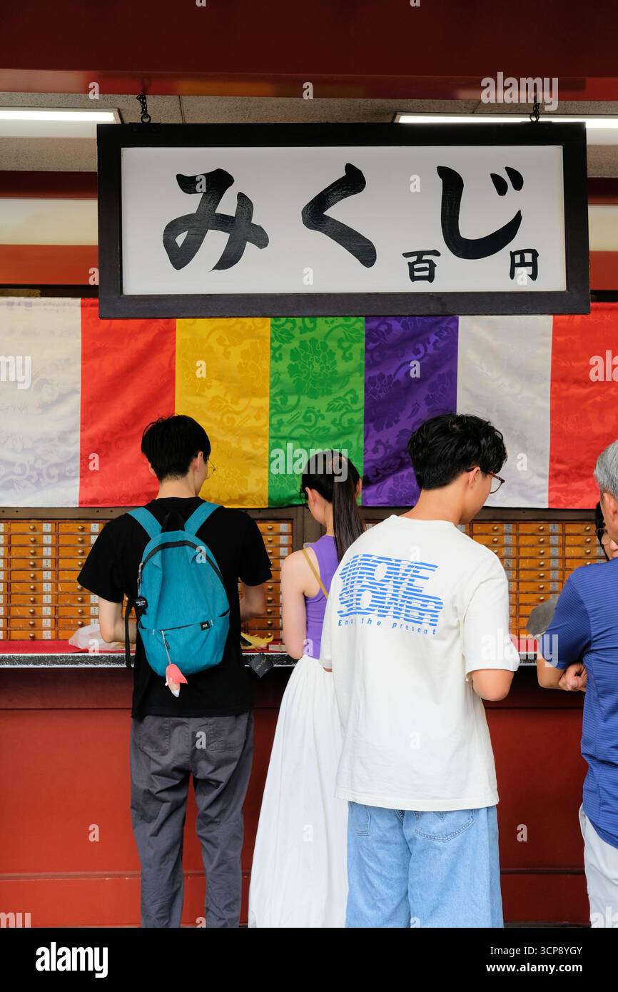 Visitors buying and drawing omikuji paper fortunes at Senso-ji Temple ...