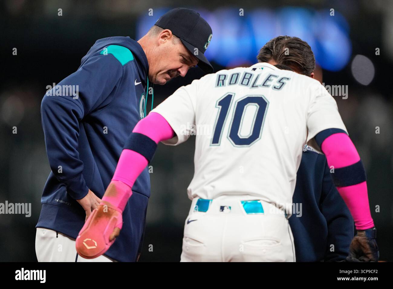 Seattle Mariners manager Dan Wilson, left, checks on Victor Robles ...
