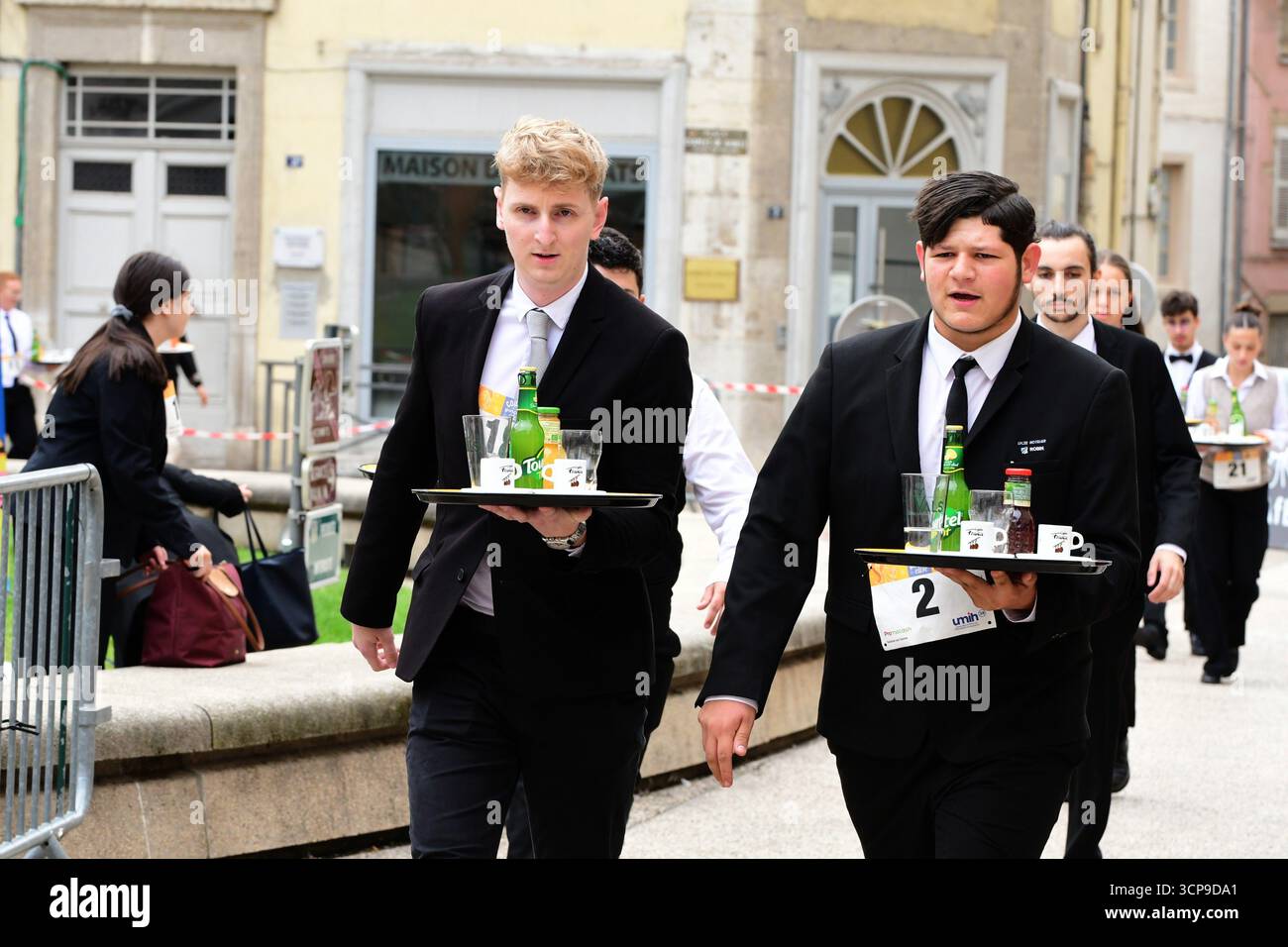 Participants carry trays with drinks during the waiters race. Waiters ...
