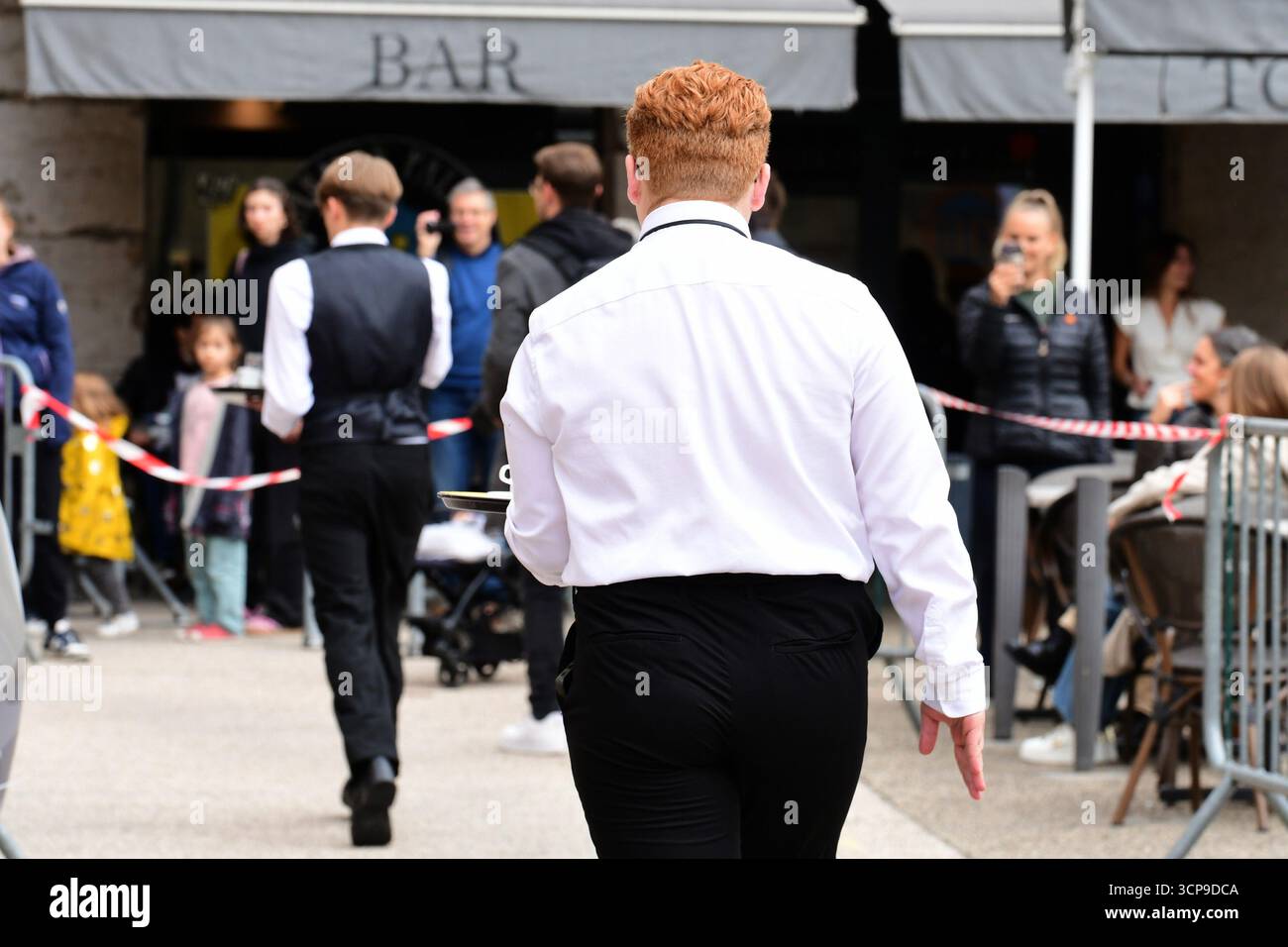 Participants carry trays with drinks during the waiters race. Waiters ...