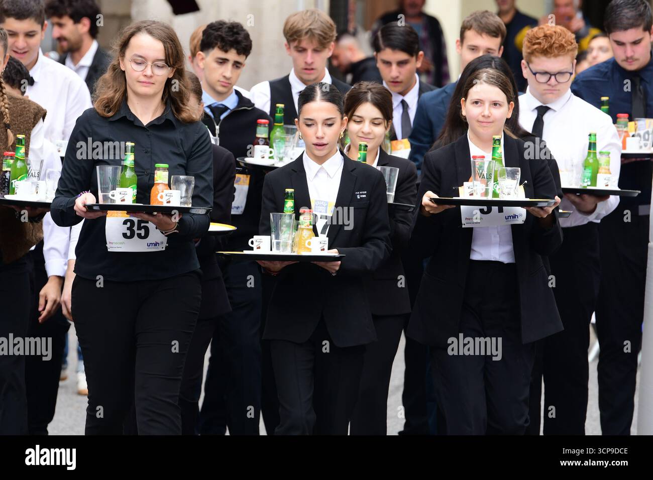 Waitresses carry trays with drinks during the waiters race. Waiters ...
