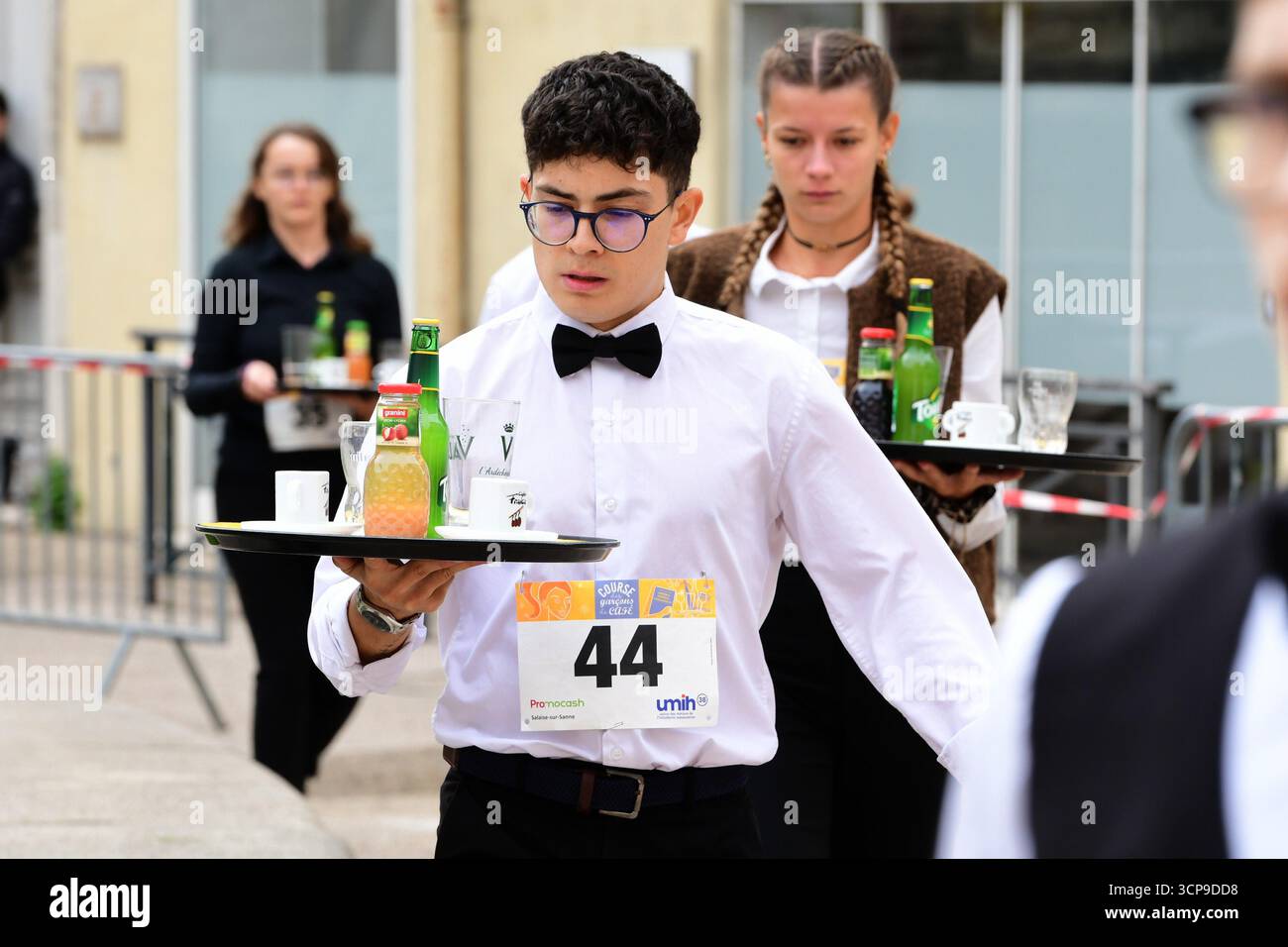 Participants carry trays with drinks during the waiters race. Waiters ...