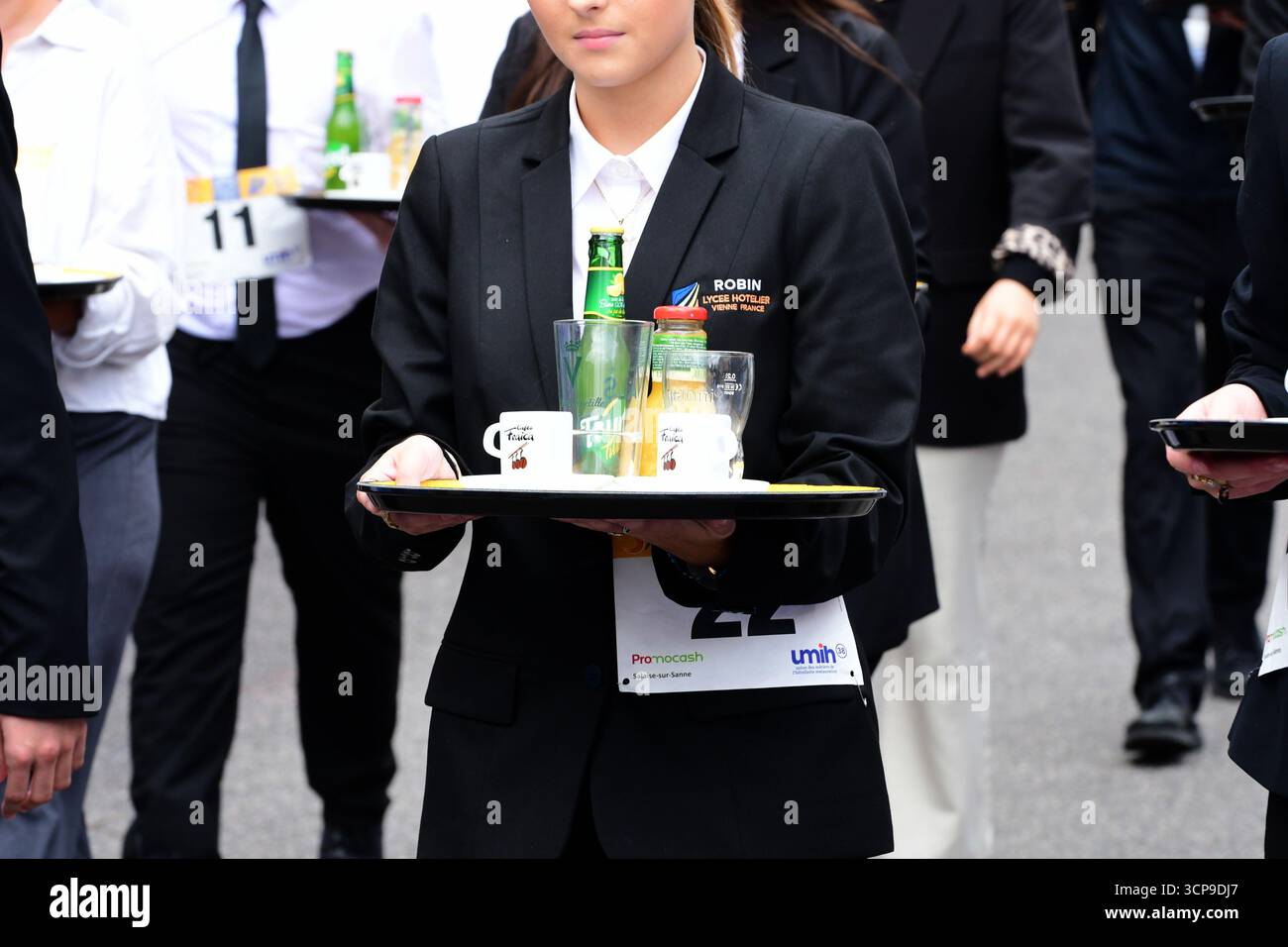 A participant carries a tray with drinks during the waiters race ...