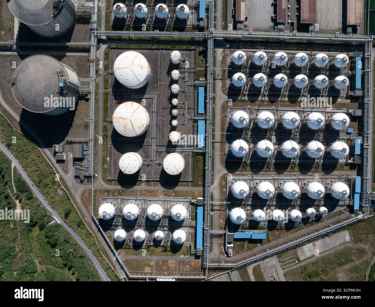 Aerial views of industrial areas with numerous large storage tanks ...
