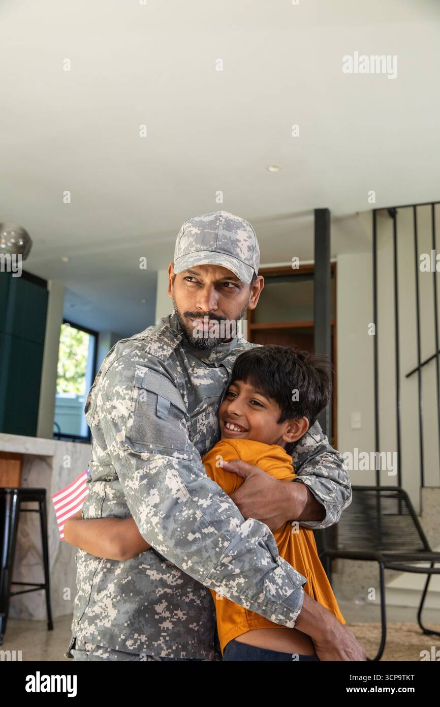 Indian father and son in camouflage uniform hugging inside home entry ...