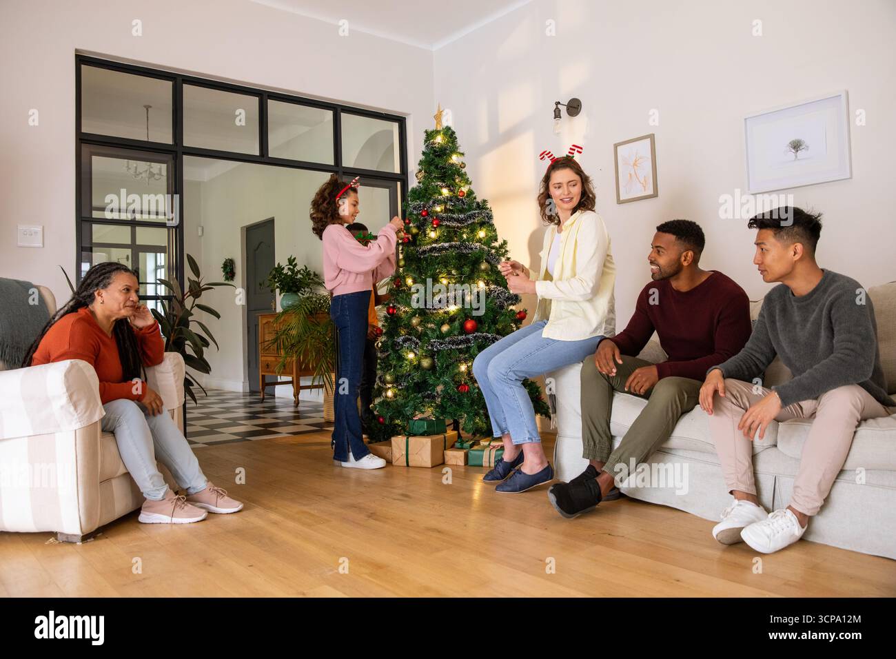 Diverse family sitting around festive hi-res stock photography and ...