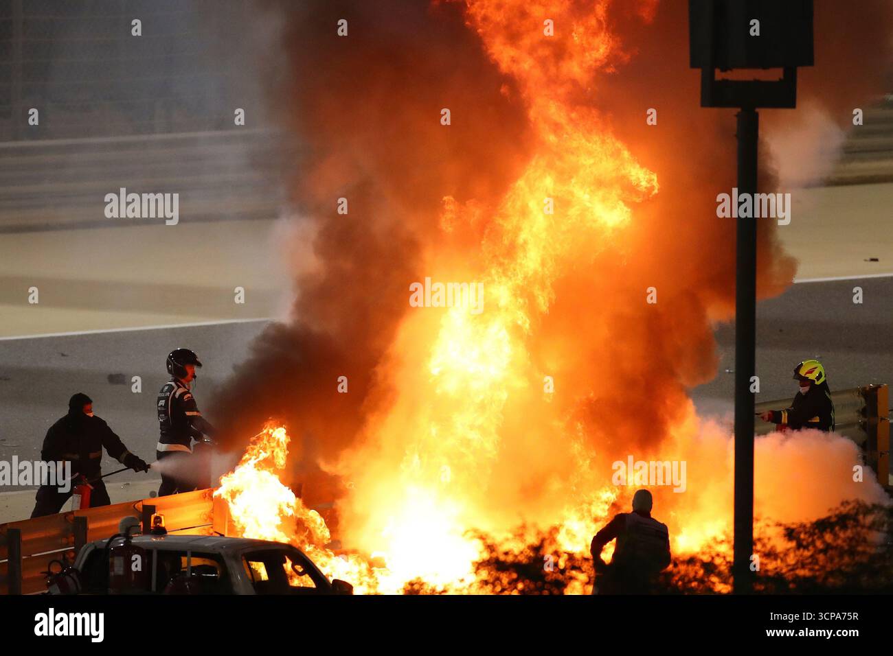 FILE - Staff extinguish flames from Haas driver Romain Grosjean's car ...