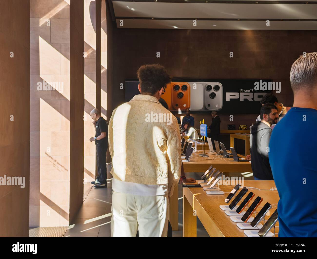 Paris, France - Sep 19, 2025: Shoppers inside an Apple Store examine ...