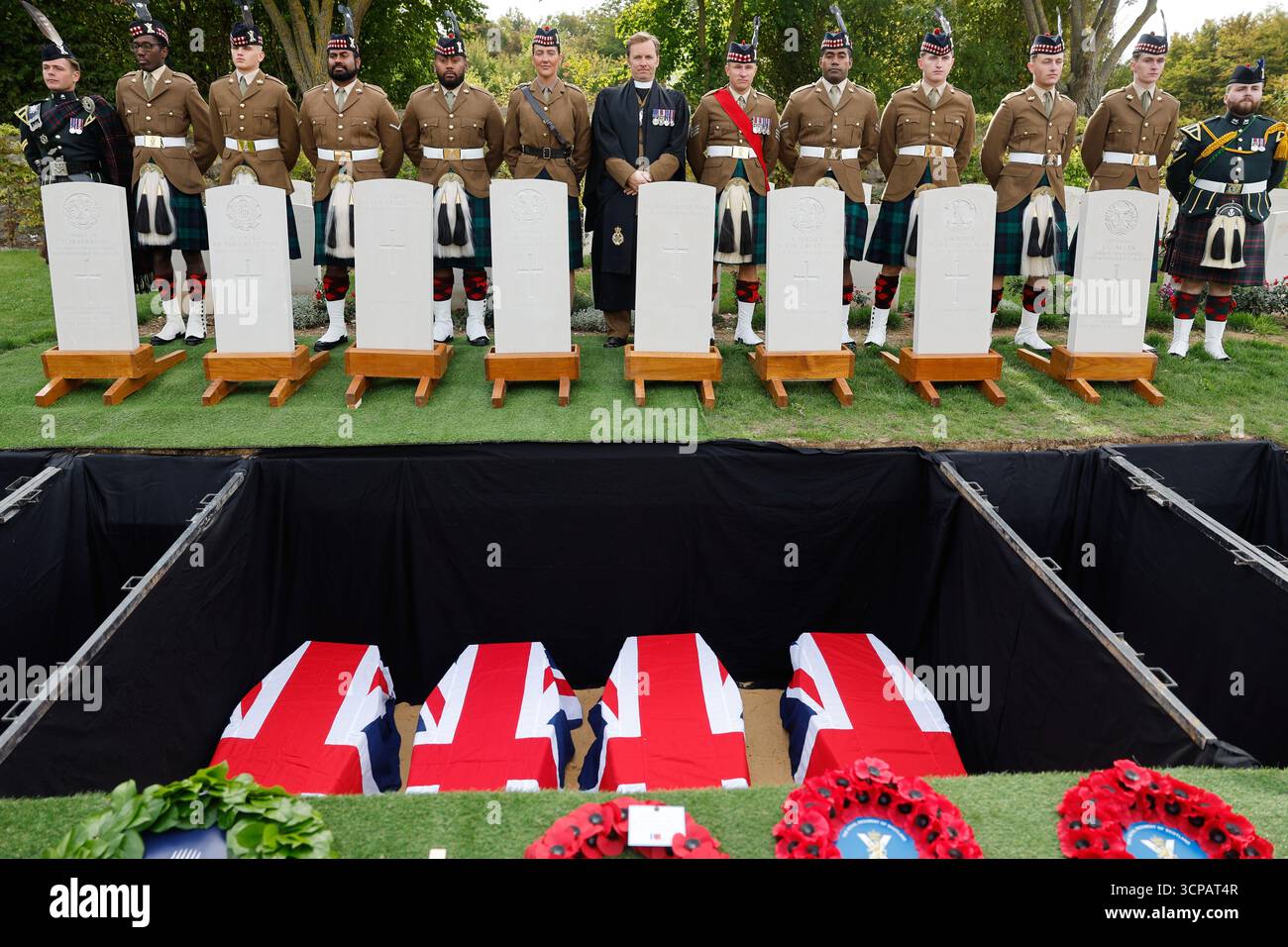 Pallbearers stand over the coffins of four unnamed World War I soldiers ...