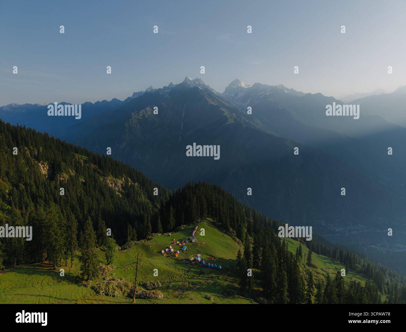 Aerial view of the lush green mountain slopes dotted with tents ...