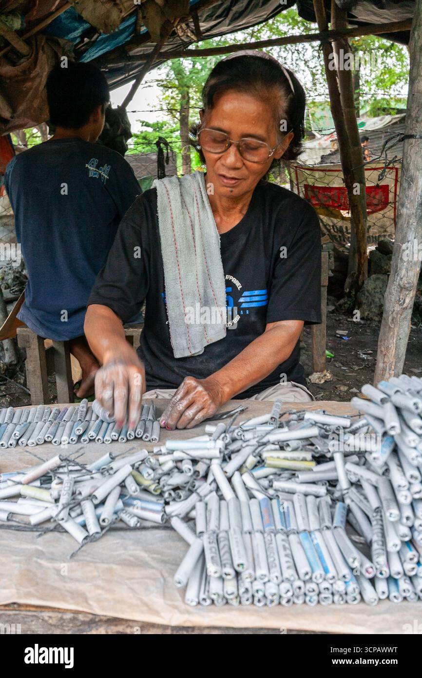 A local worker with no safety protection assembling firecrackers at a ...