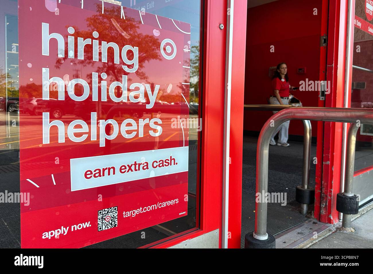 A hiring holiday helpers sign is displayed at a retail store in ...
